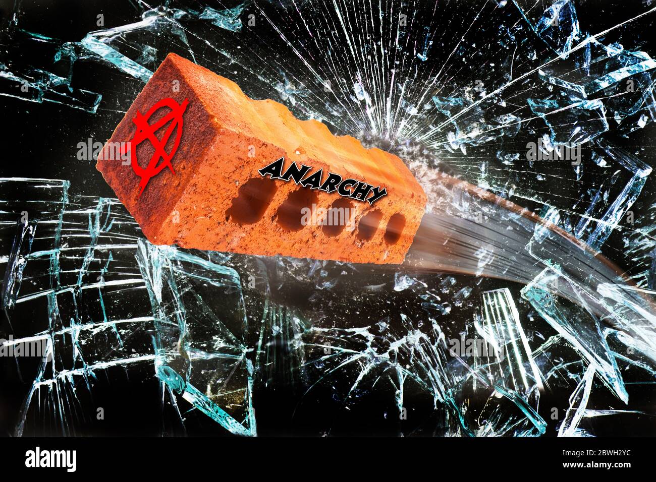 Broken Anarchy flying brick breaking glass window Stock Photo - Alamy