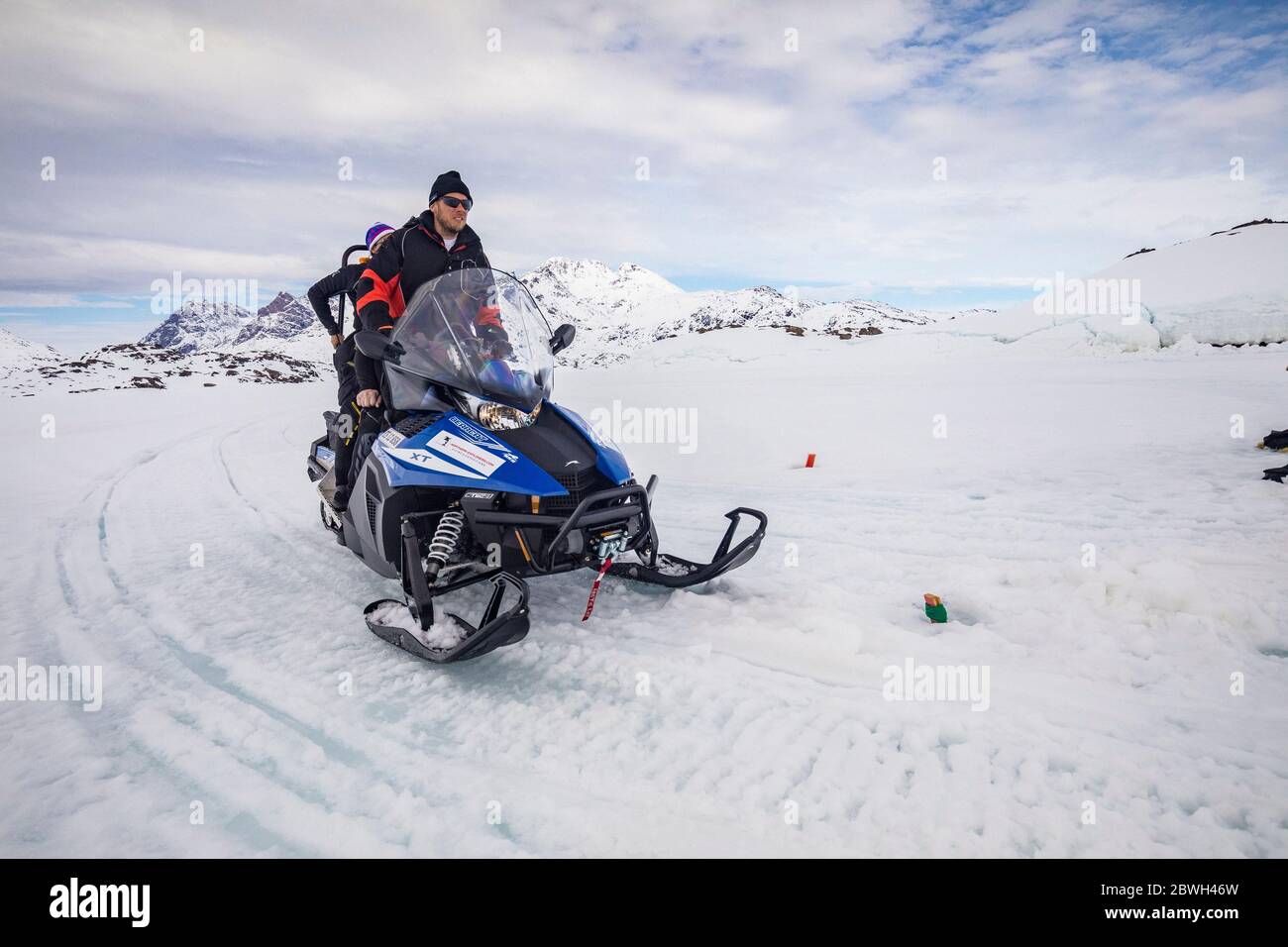 Transporting people and equipment with snowmobile to the ice field ...
