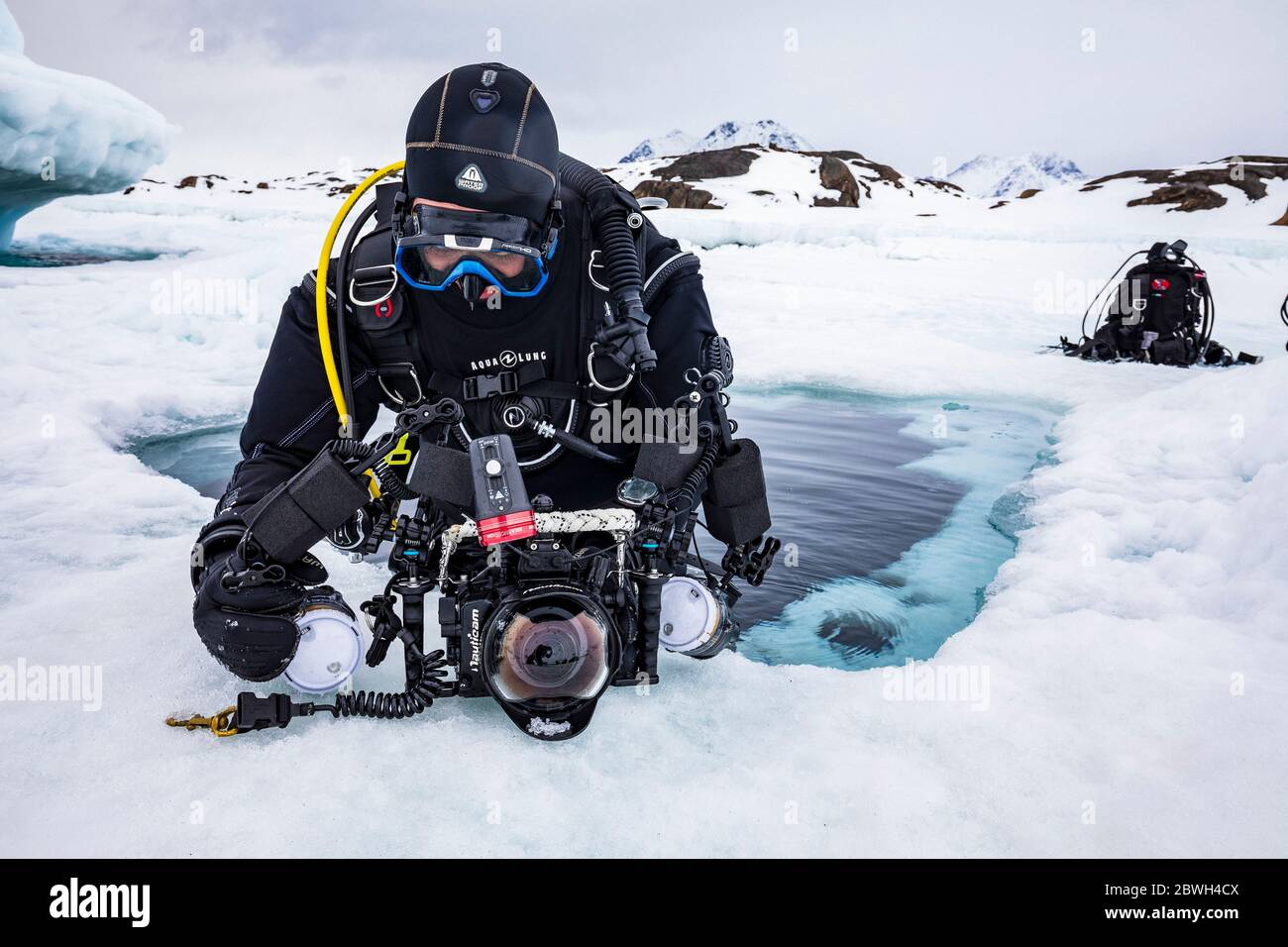 Divers checking the photo camera before to dive under the ice and ...