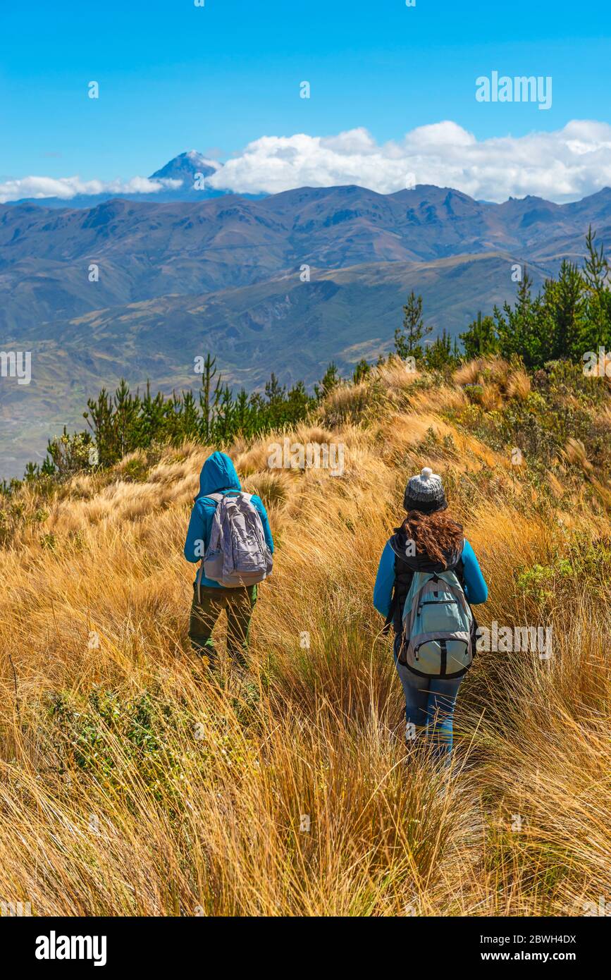 Two female tourists and backpackers hiking the Quilotoa Loop around the ...