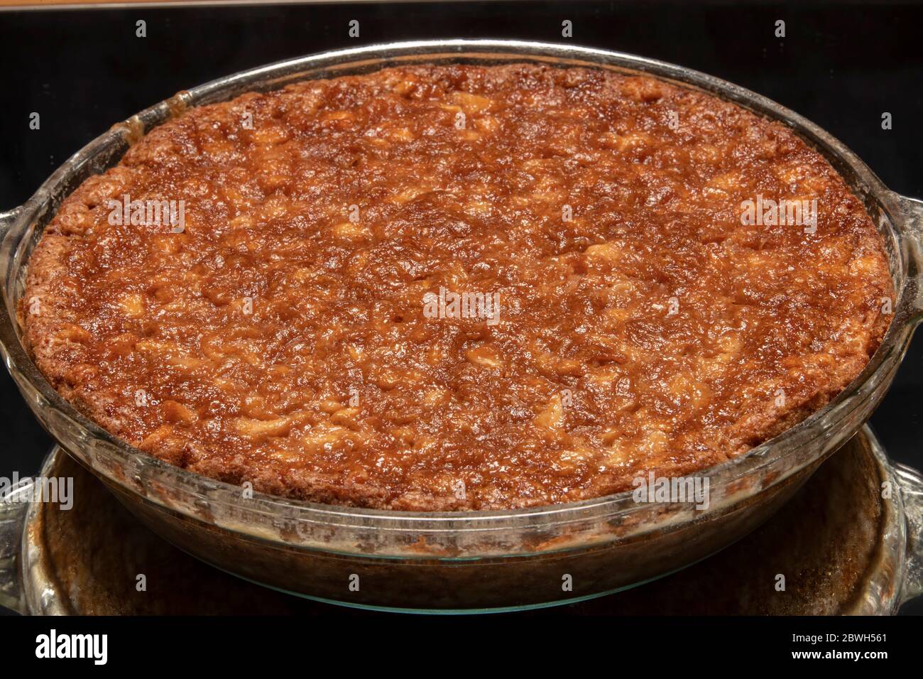 apple cake in round glass baking dish on mirror Stock Photo - Alamy