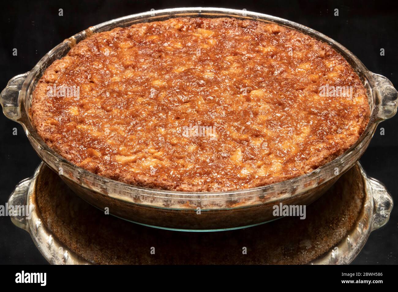 apple cake in round glass baking dish on mirror Stock Photo - Alamy