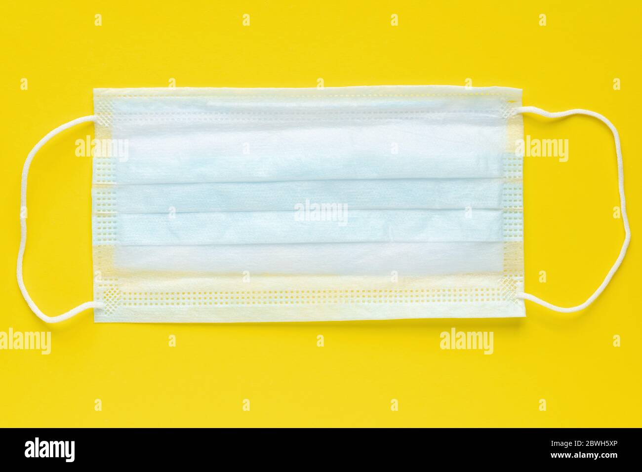 Medical surgical face mask on yellow background. World pandemic ...