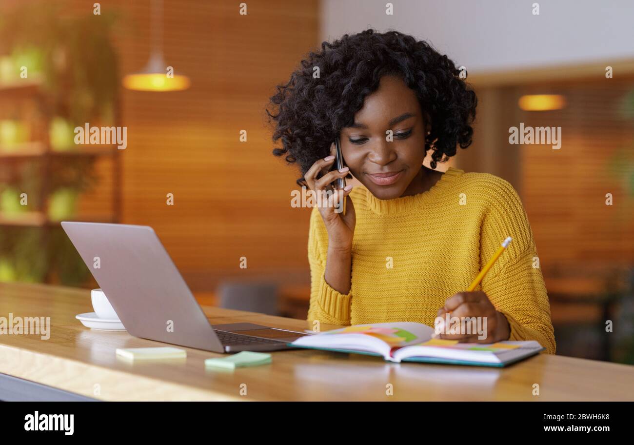 Business woman taking notes while talking with client on phone Stock ...