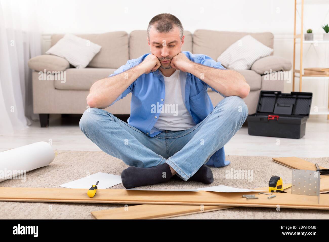 Man Sitting Near Disassembled Shelf Having Problems Installing ...