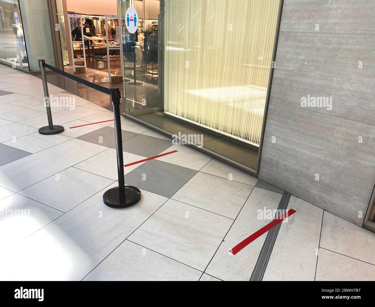 Red lines for people queuing near a store in a shopping center. Concept ...