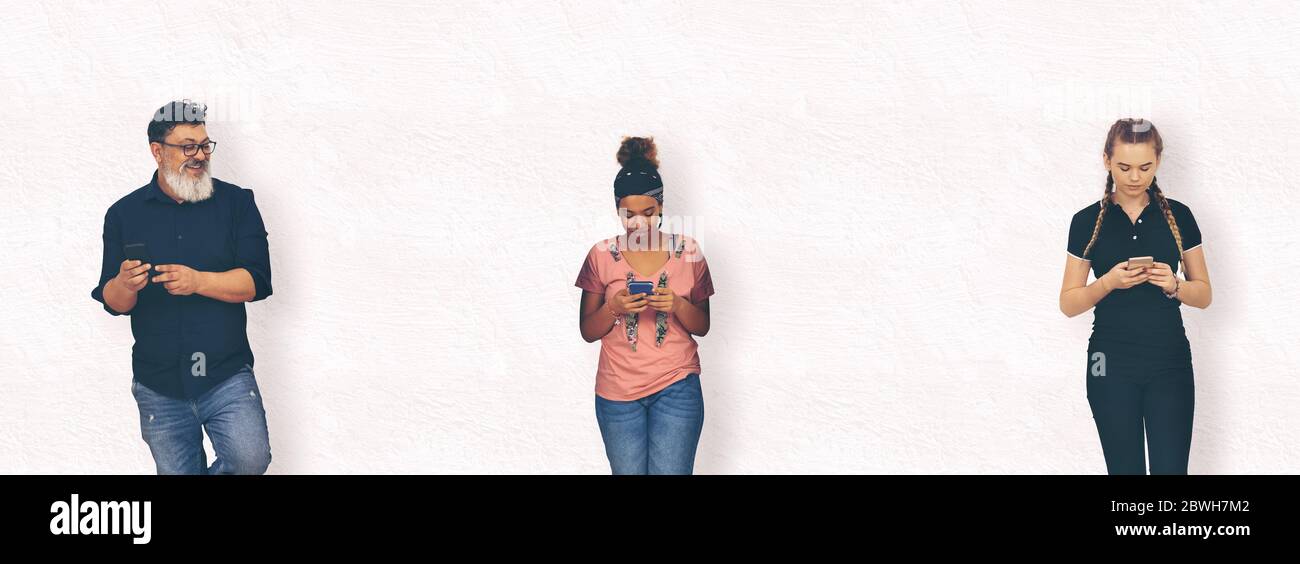 Multiracial friends using mobile phones while keeping social distance ...