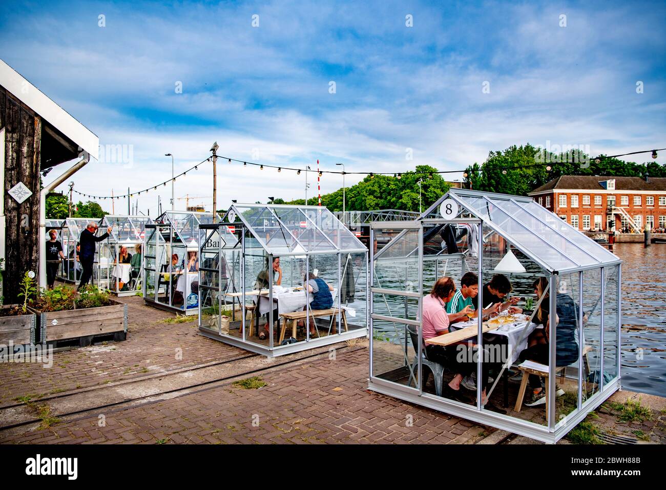 Customers sit in small glasshouses as they enjoy their dinner while ...