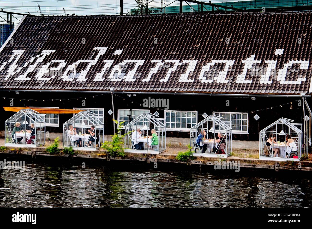Customers sit in small glasshouses as they enjoy their dinner while ...