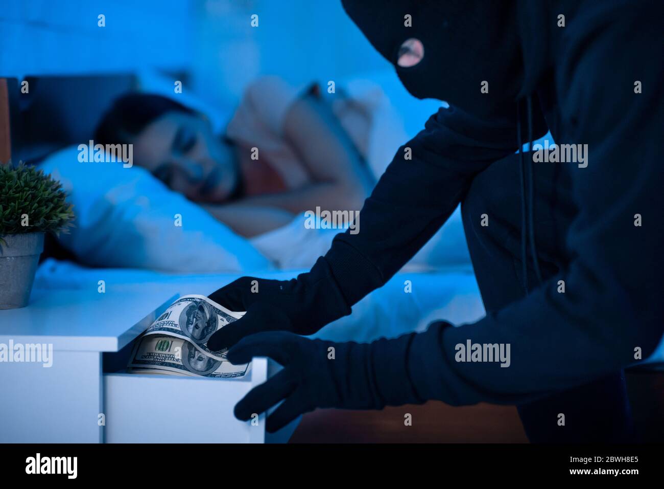 Thief stealing in the night in house with tenant sleeping Stock Photo ...