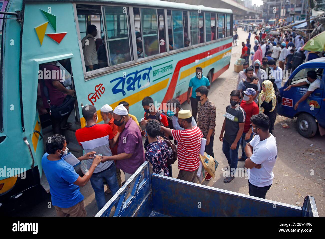 A few commuters jostle as they try to board a bus in the city, as road ...