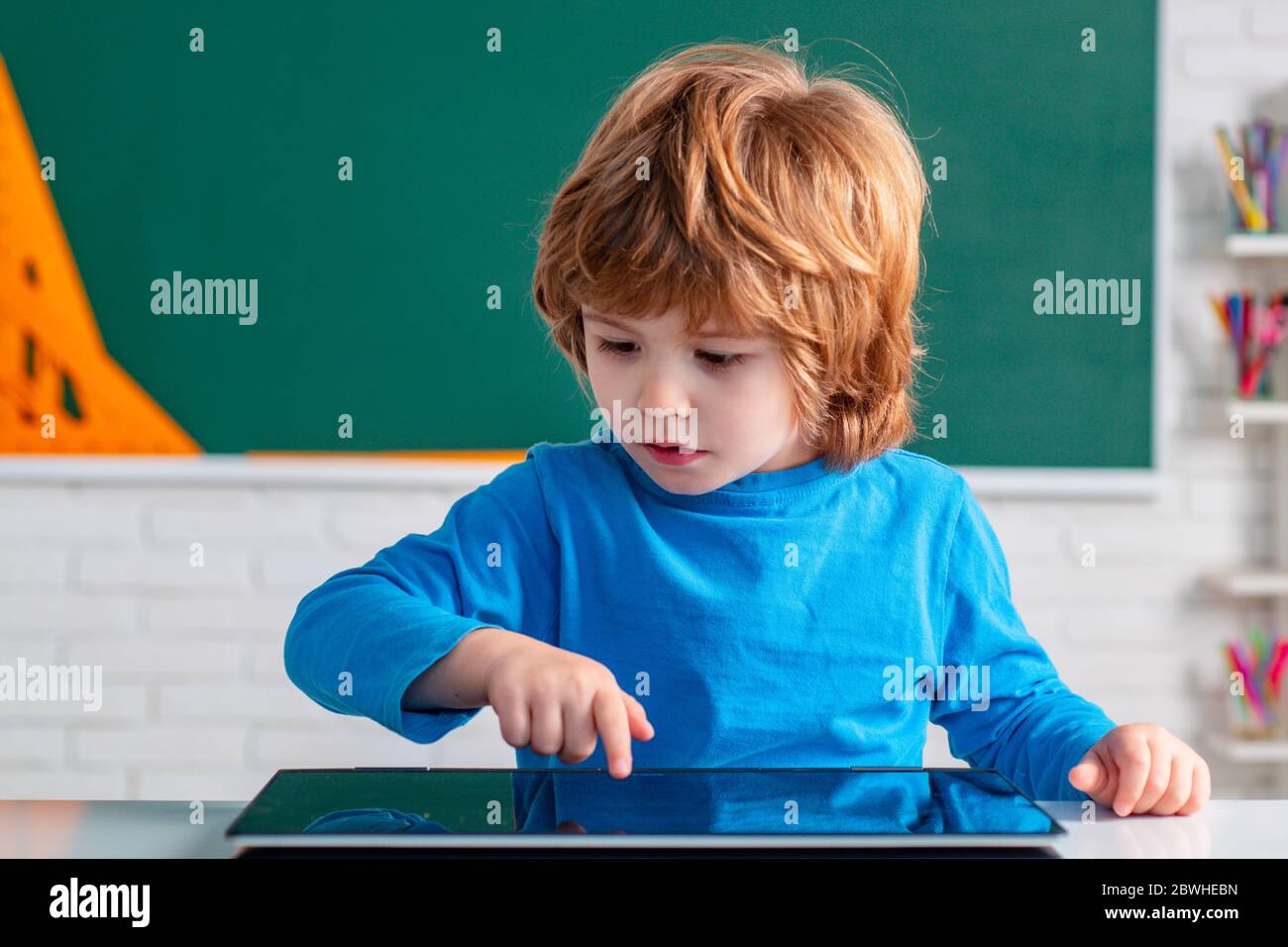 School child with tablet in school classroom. Children learning. Kids ...