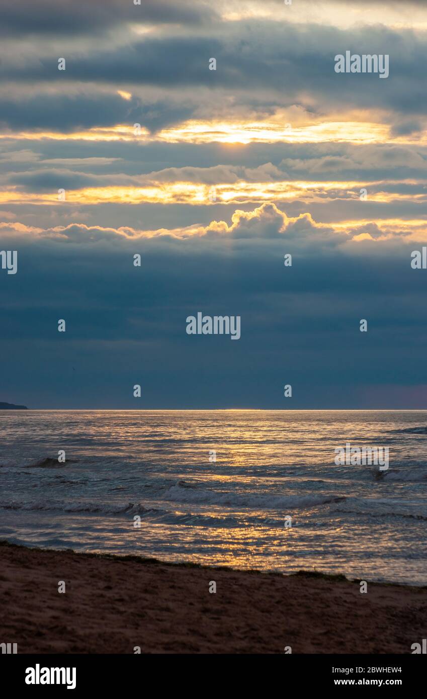 Ocean swell with breaking waves. Sunlight shining through openings in ...