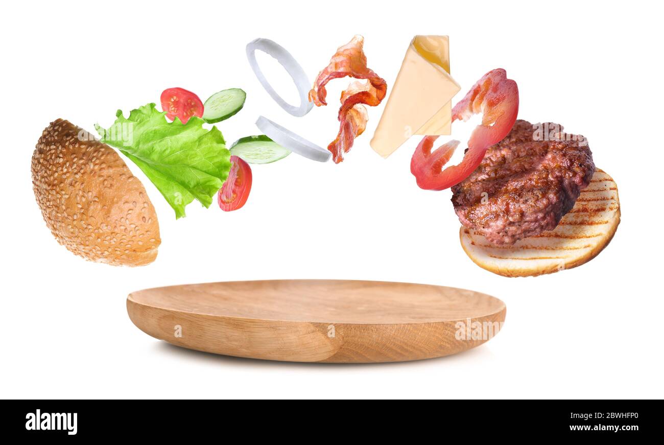 Plate with flying ingredients of burger on white background Stock Photo ...