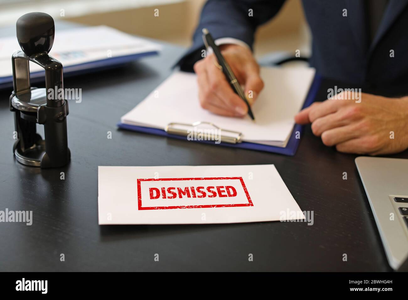 Paper with text DISMISSED on table of office worker Stock Photo - Alamy