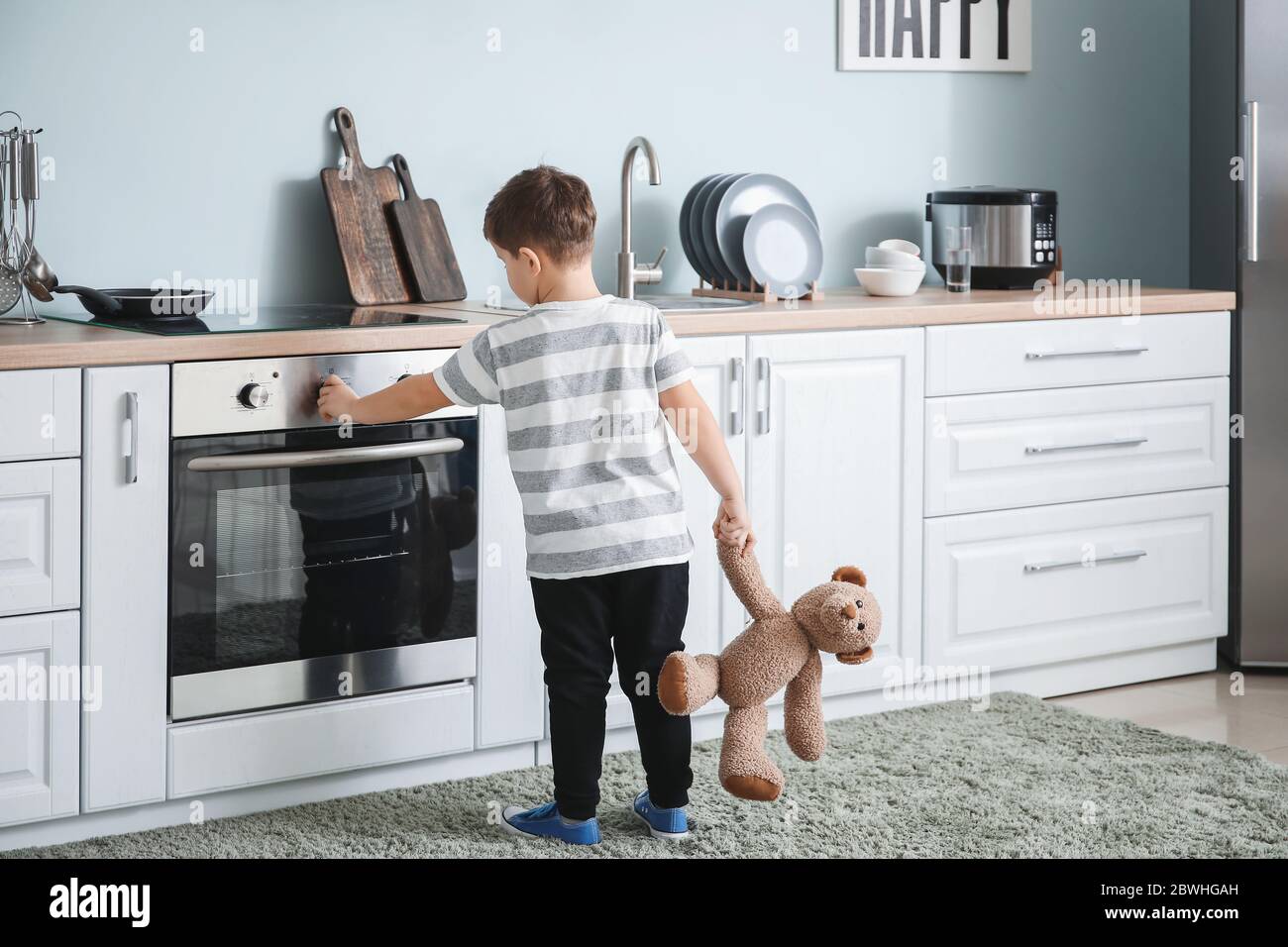 Little boy playing with electric oven at home Stock Photo - Alamy