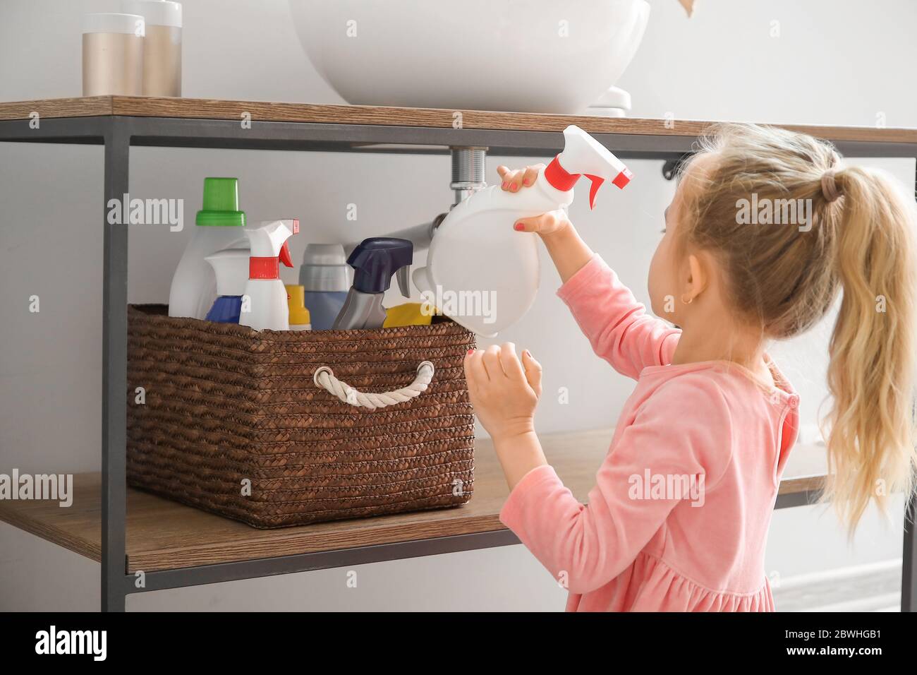 Little girl playing with cleaning supplies at home Stock Photo - Alamy