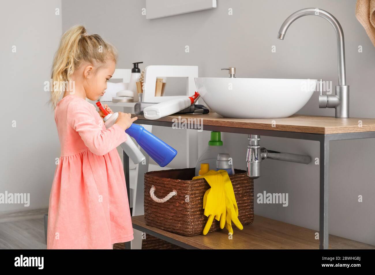 Little girl playing with cleaning supplies at home Stock Photo - Alamy