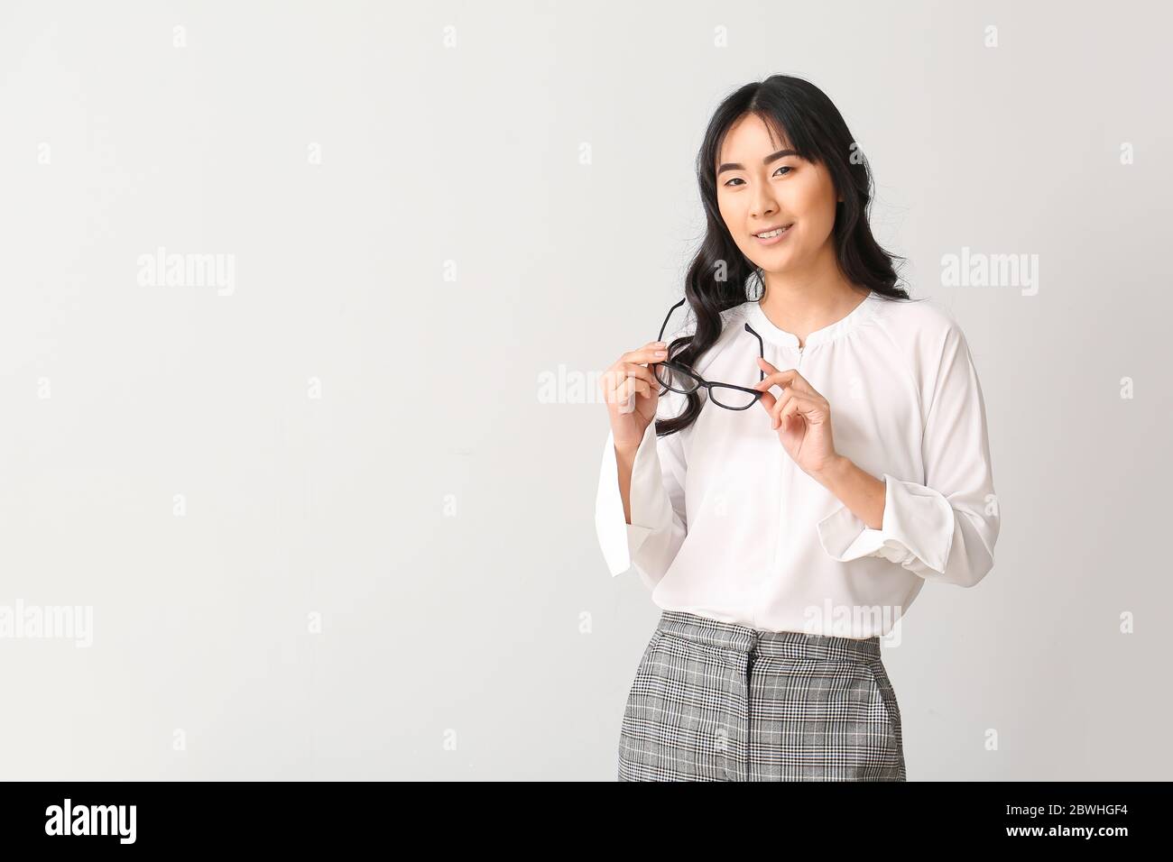 Beautiful Asian secretary on light background Stock Photo - Alamy