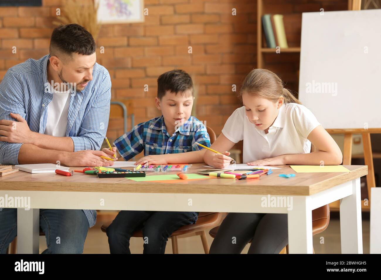 Drawing teacher giving optional classes at school Stock Photo - Alamy