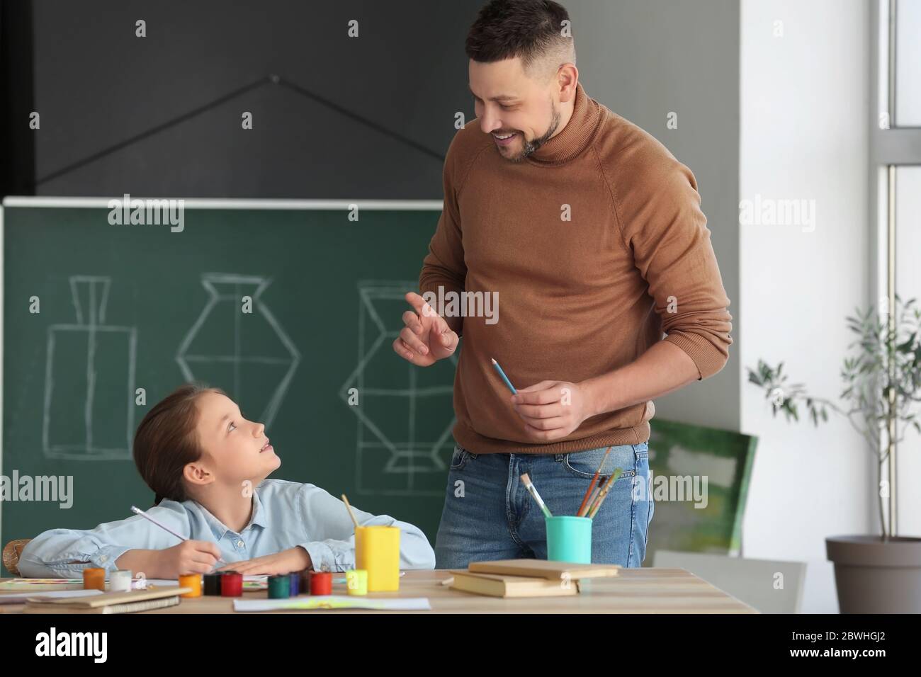 Drawing teacher giving optional classes at school Stock Photo - Alamy
