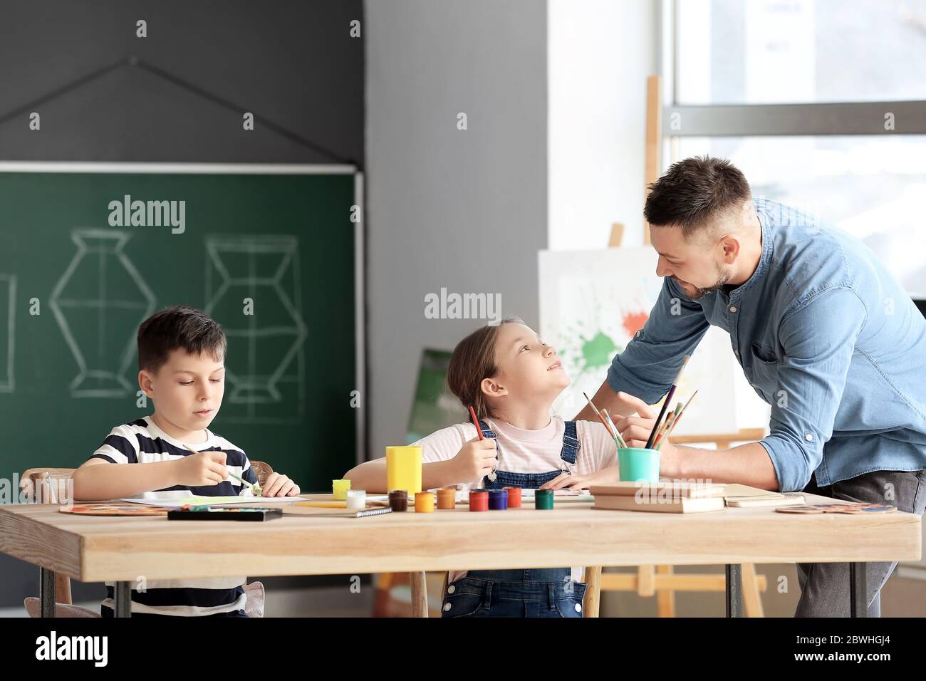 Drawing teacher giving optional classes at school Stock Photo - Alamy