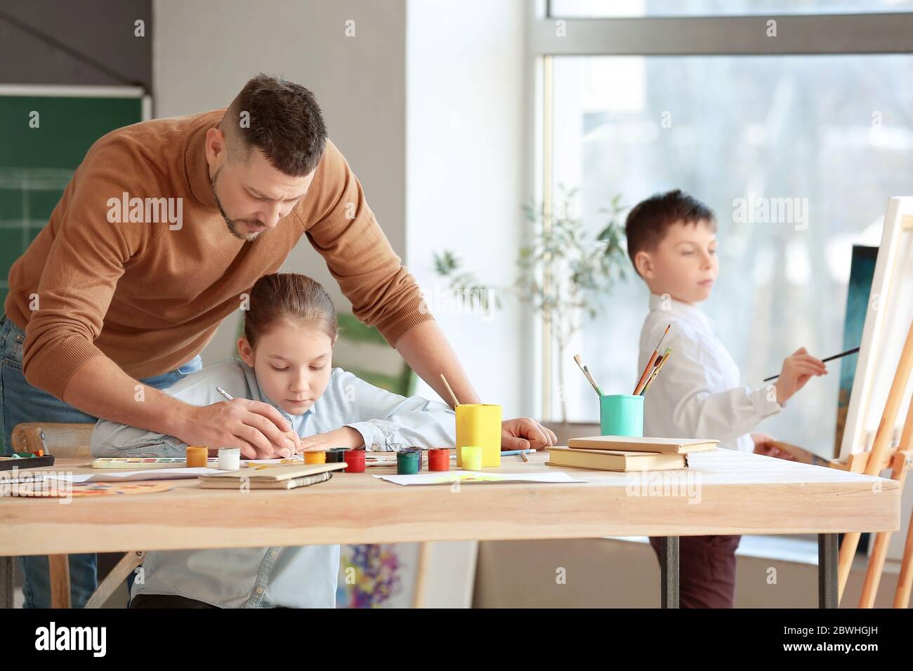 Drawing teacher giving optional classes at school Stock Photo - Alamy