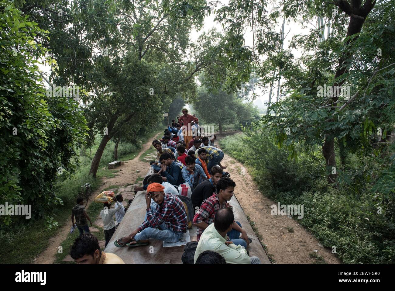 Men on top of overcrowded train passing through countryside in Madhya ...