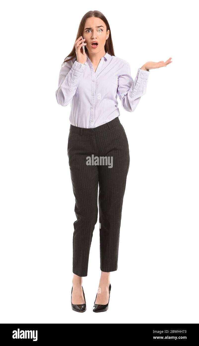 Shocked young secretary talking by phone on white background Stock ...