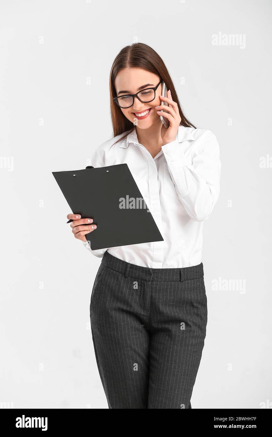 Beautiful young secretary talking by phone on white background Stock ...