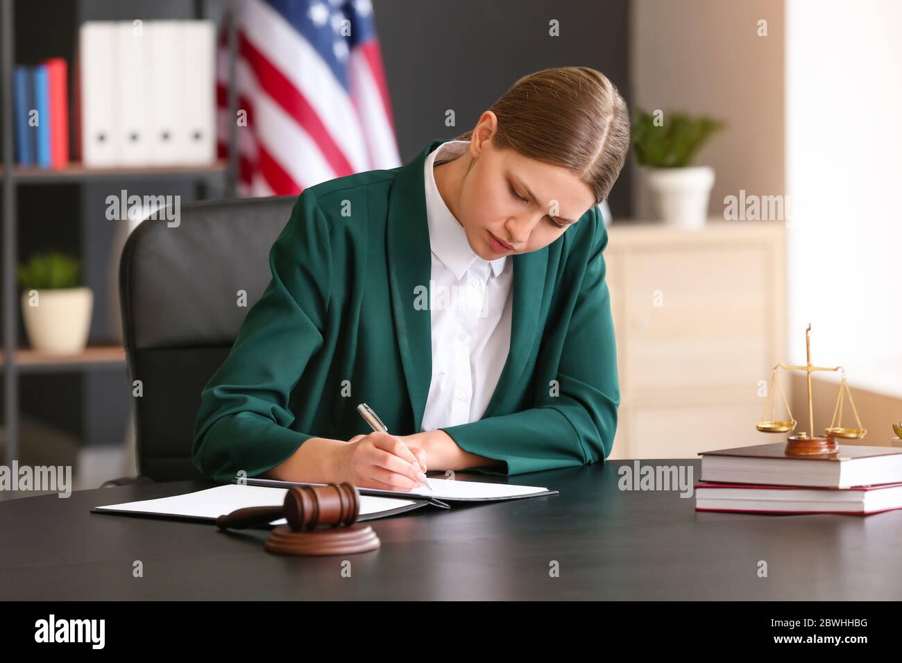 Female judge with documents at table in office Stock Photo - Alamy