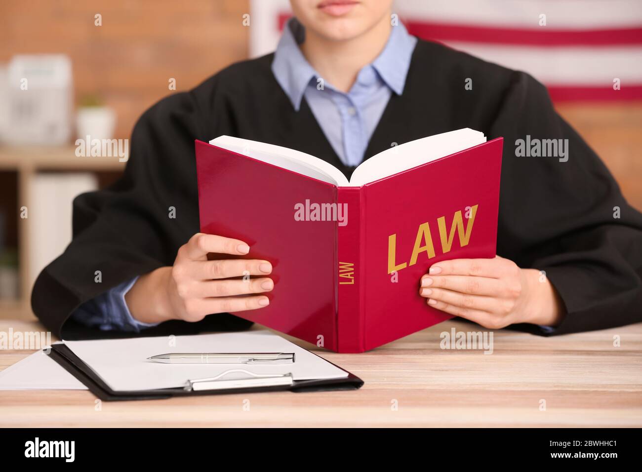 Female judge with law book at table in office Stock Photo - Alamy
