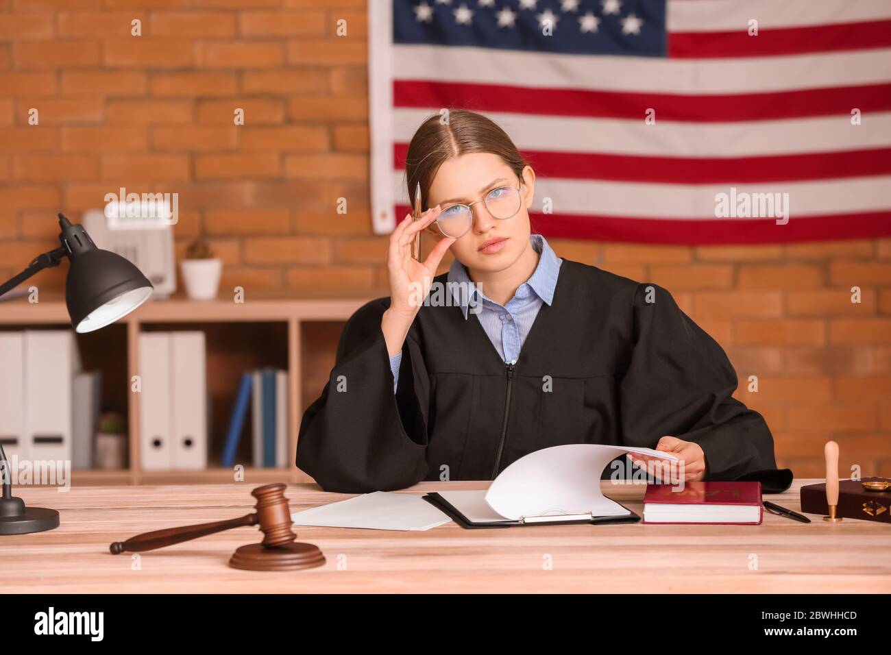 Female judge with documents at table in office Stock Photo - Alamy