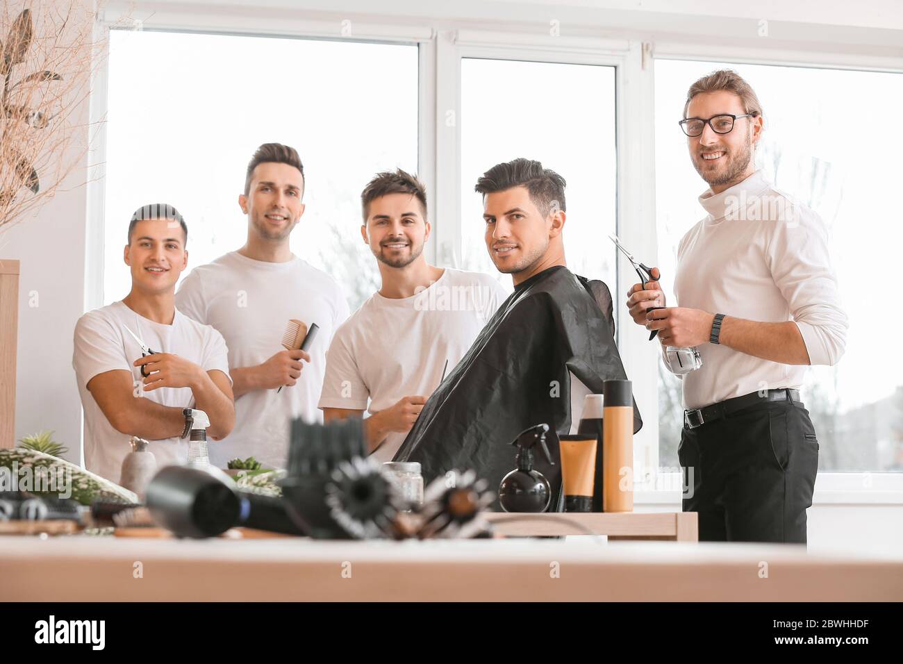 Professional hairdresser teaching young men in salon Stock Photo - Alamy