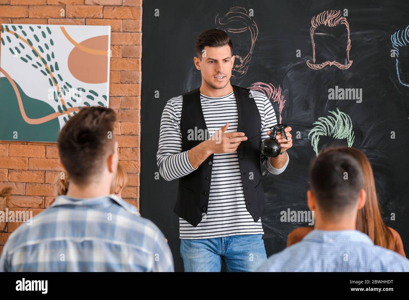 Professional hairdresser teaching young people in salon Stock Photo - Alamy