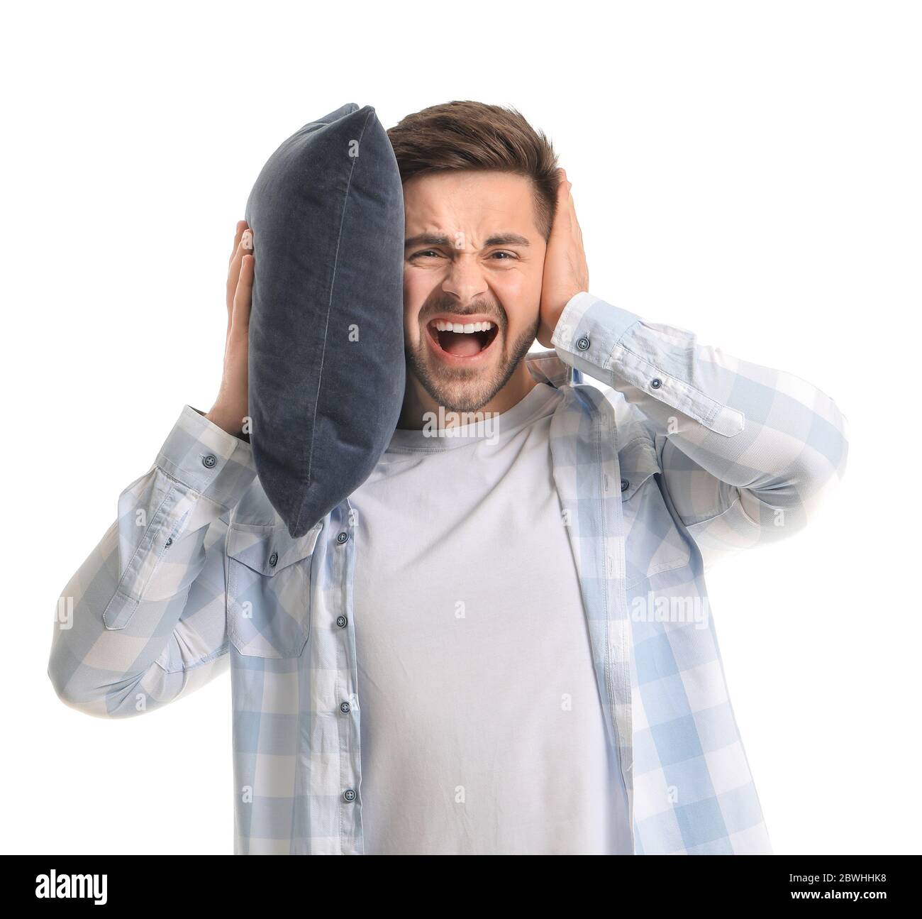 Young man suffering from loud noise on white background Stock Photo - Alamy