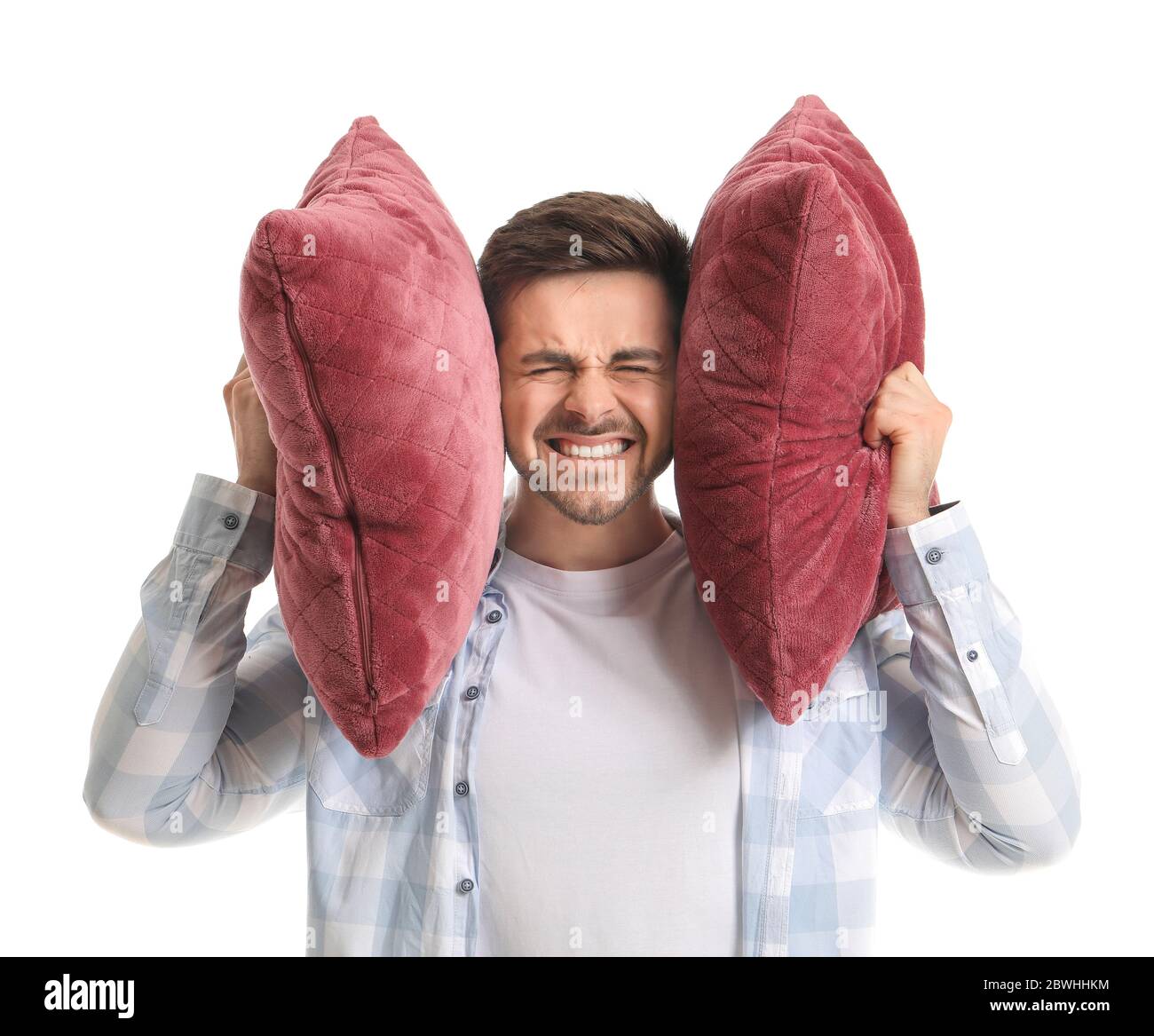 Young man suffering from loud noise on white background Stock Photo - Alamy