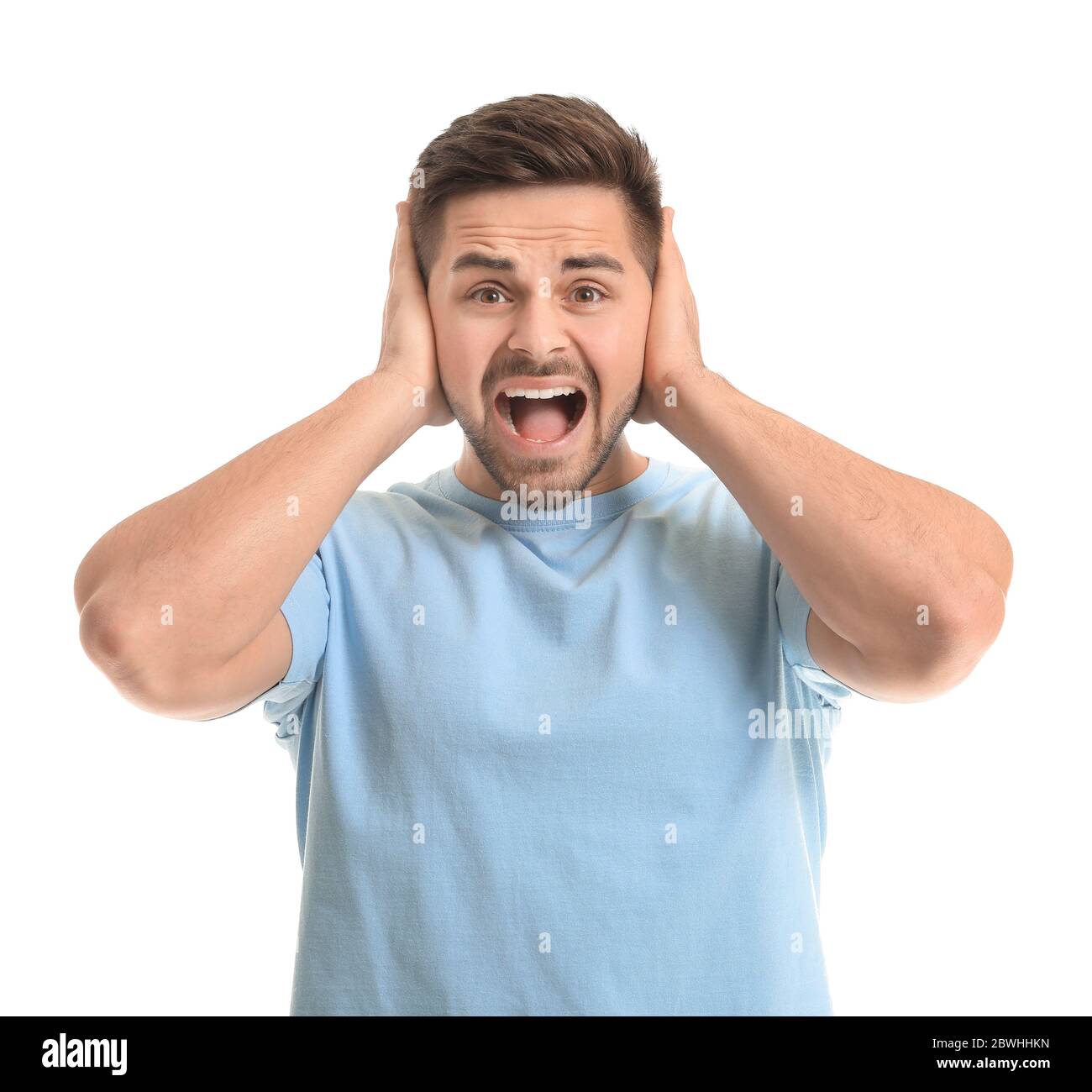 Young man suffering from loud noise on white background Stock Photo - Alamy
