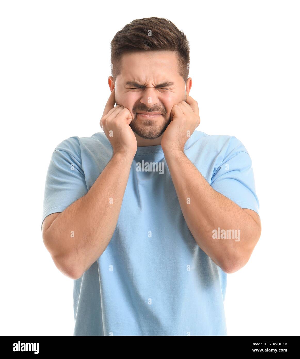 Young man suffering from loud noise on white background Stock Photo - Alamy