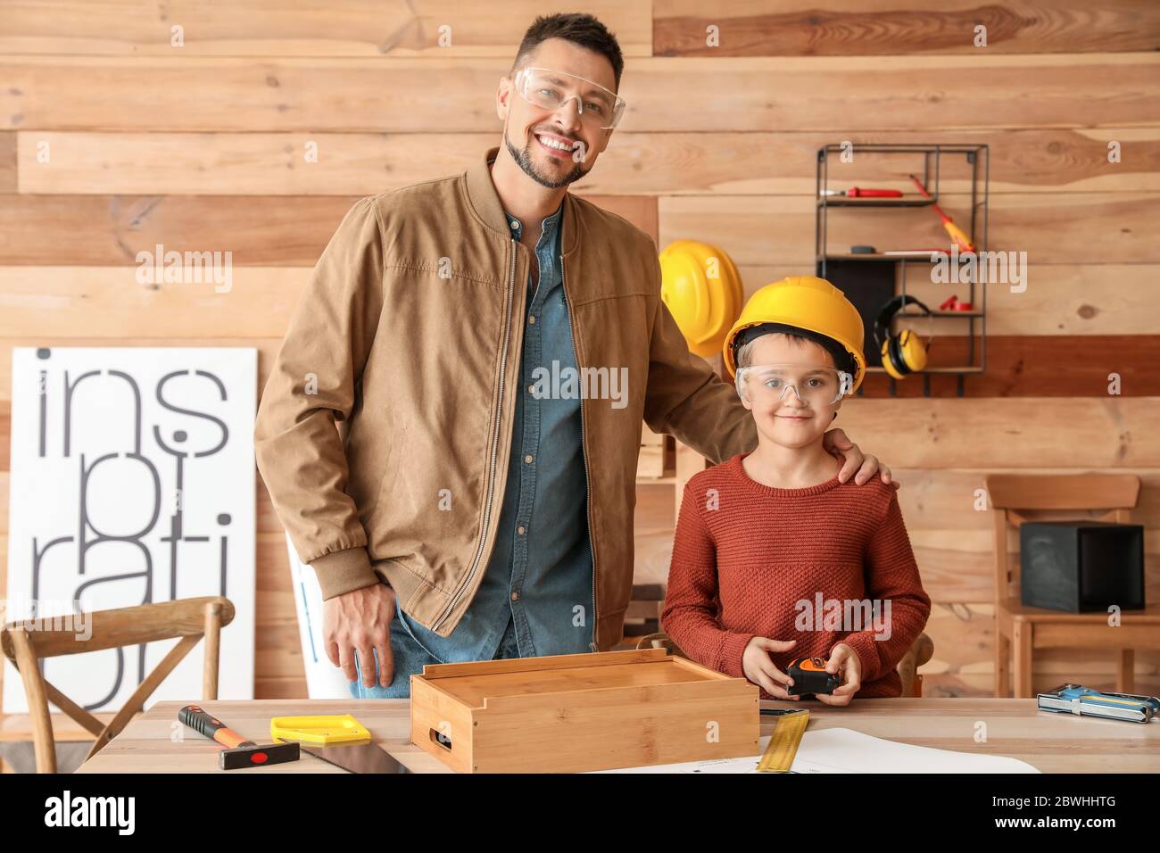 Little son helping his father in carpenter's workshop Stock Photo - Alamy
