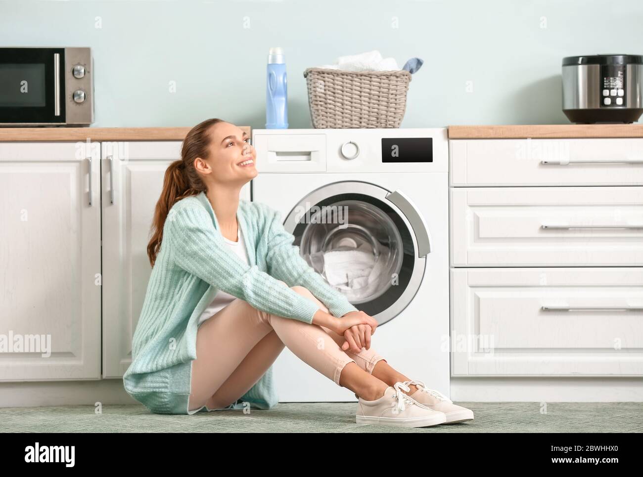 Young woman doing laundry at home Stock Photo - Alamy