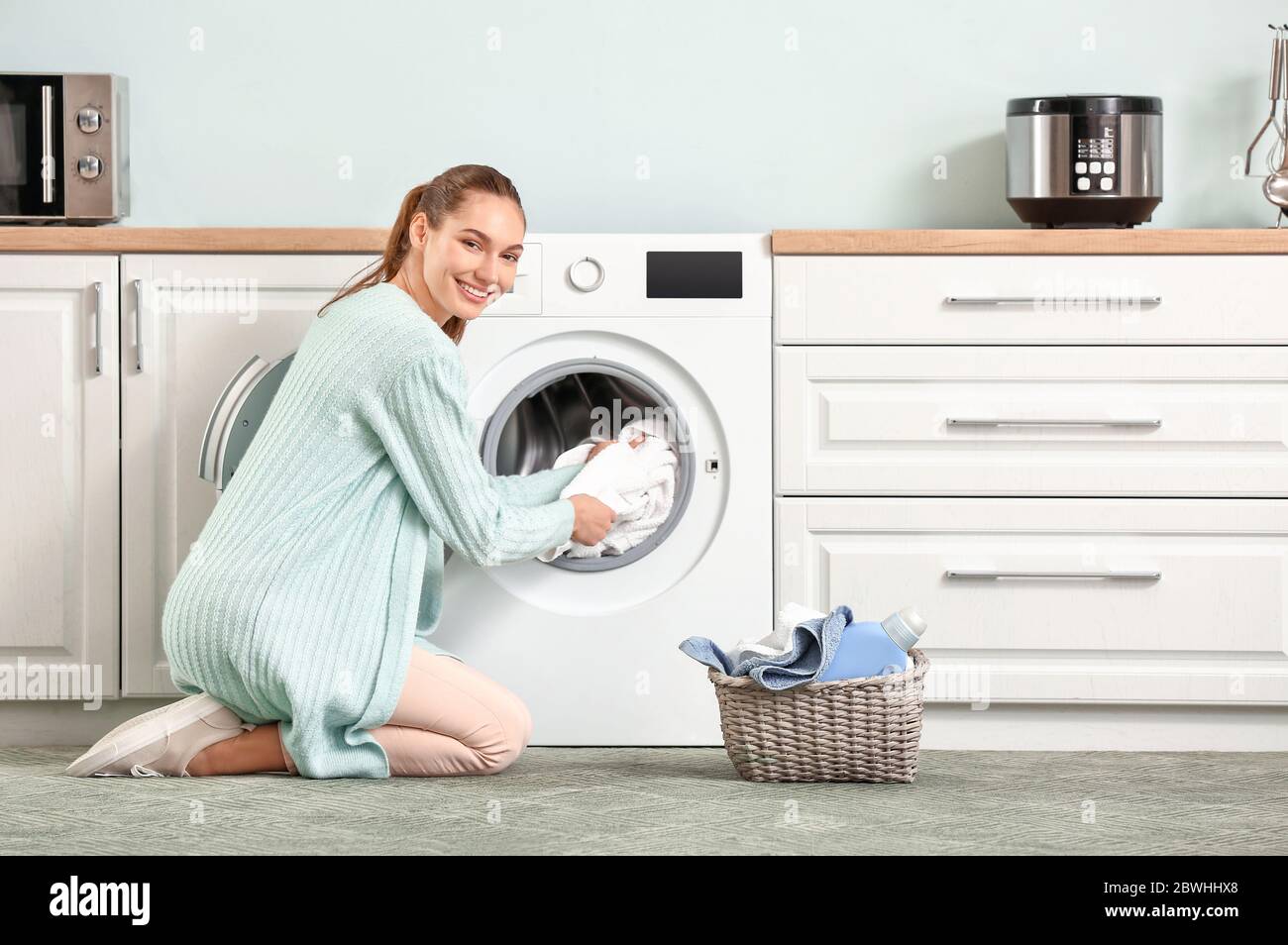 Young woman doing laundry at home Stock Photo - Alamy