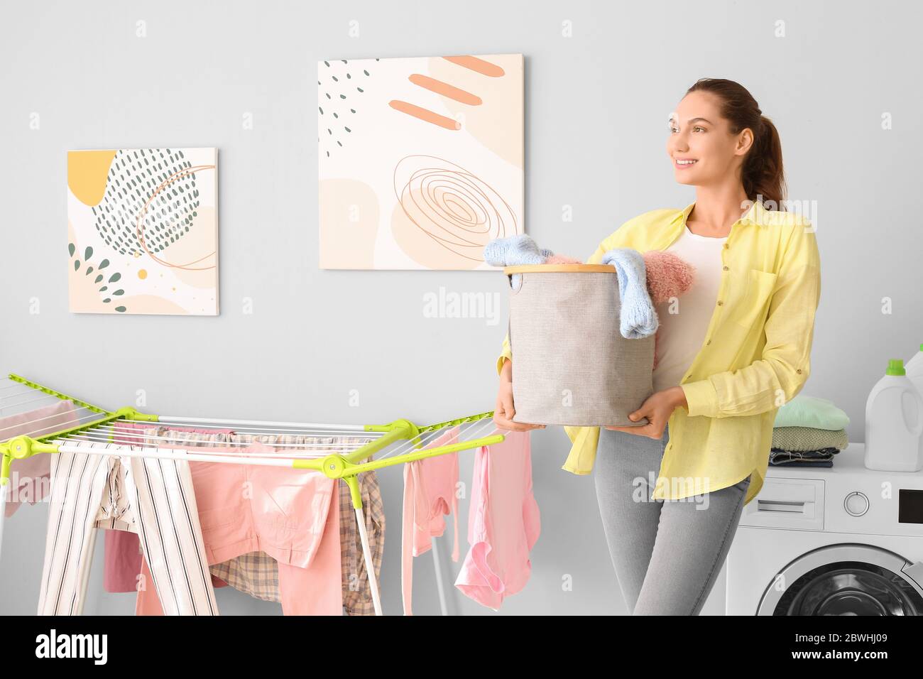 Young woman with clean laundry in bathroom Stock Photo - Alamy