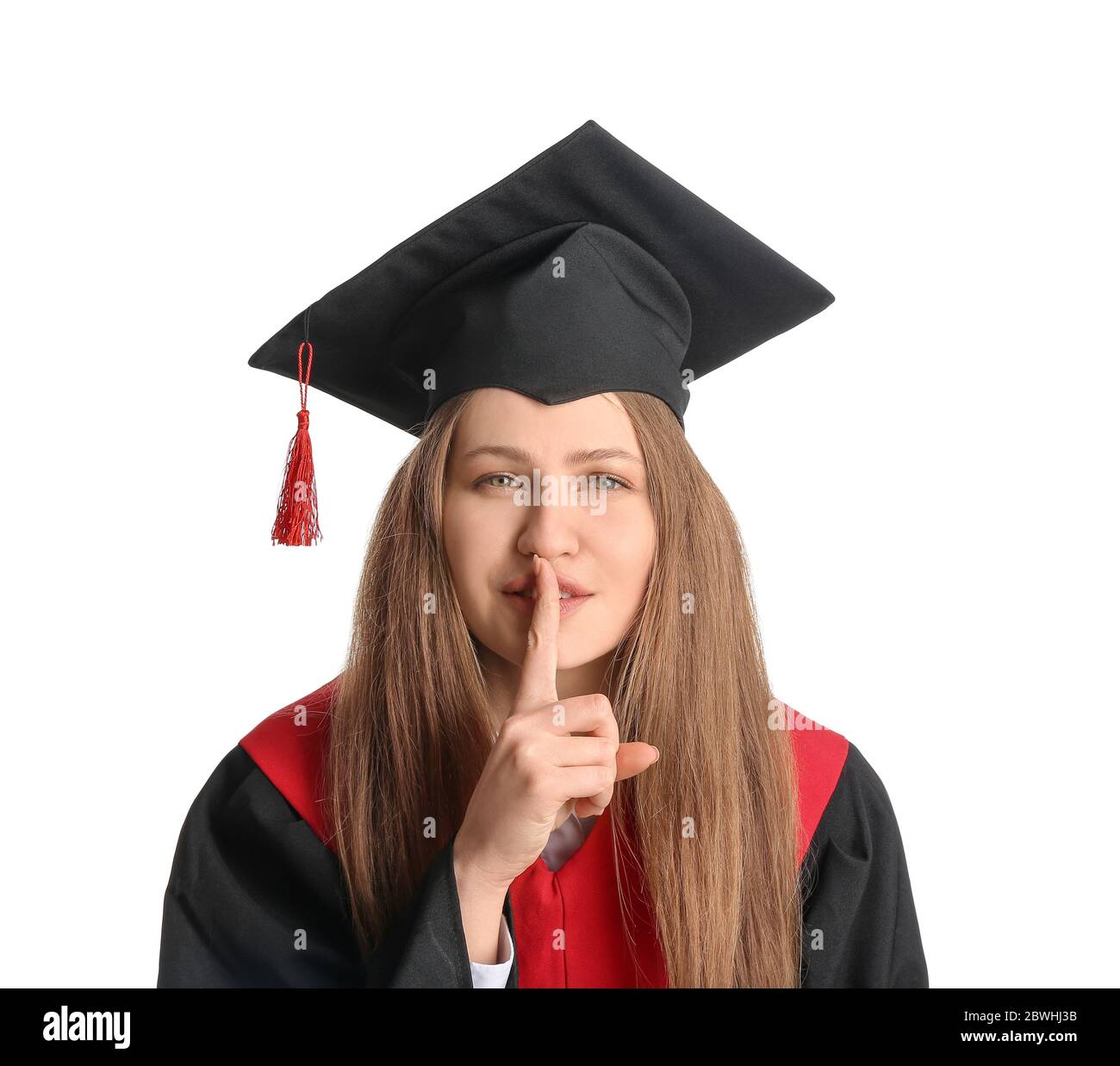 Female graduating student showing silence gesture on white background ...