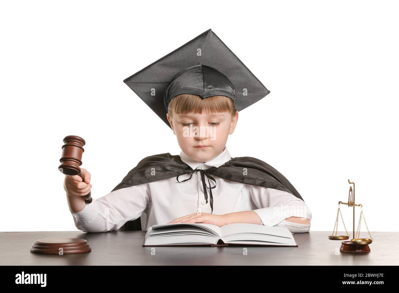 Portrait of little judge sitting at table against white background ...