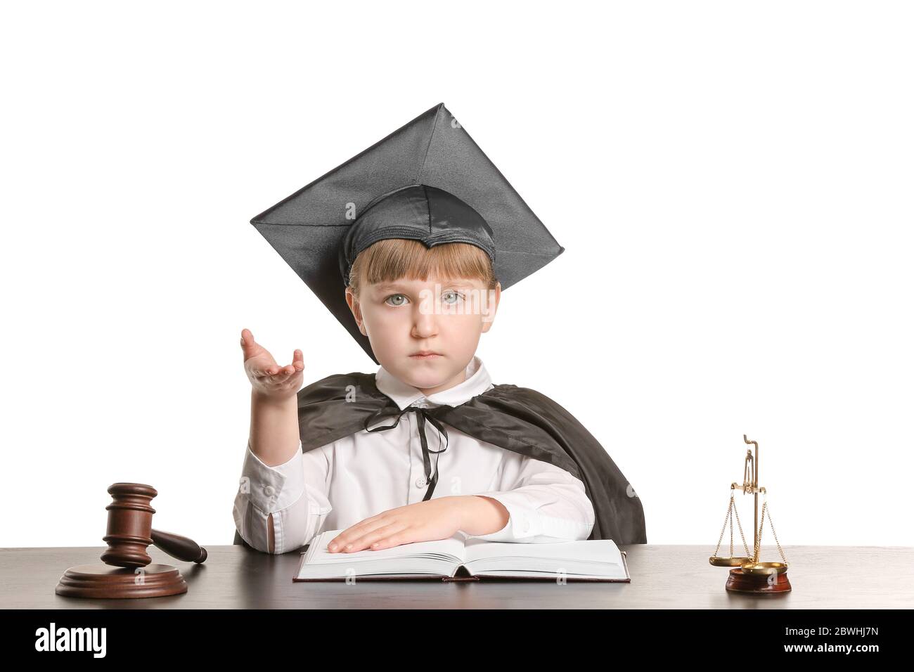 Portrait of little judge sitting at table against white background ...