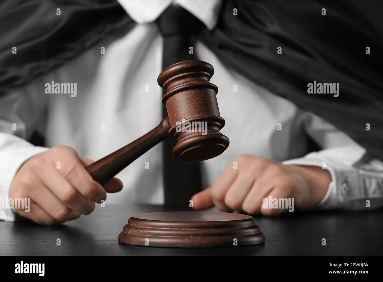 Little judge sitting at table against dark background, closeup Stock ...