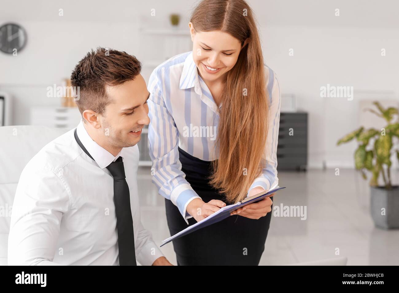 Boss and his beautiful secretary working in office Stock Photo - Alamy
