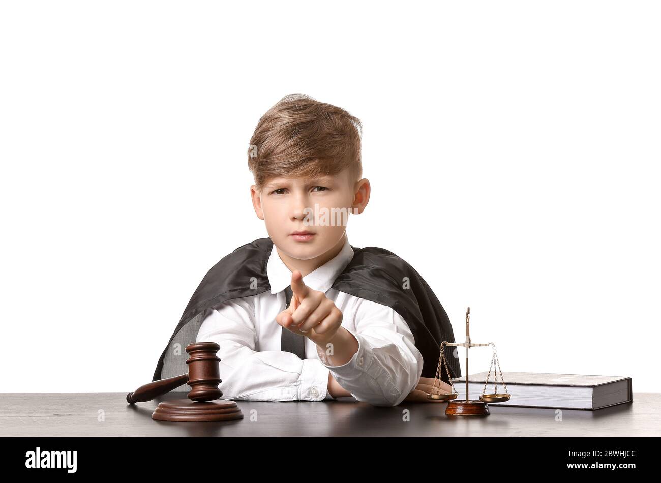 Portrait of little judge sitting at table against white background ...