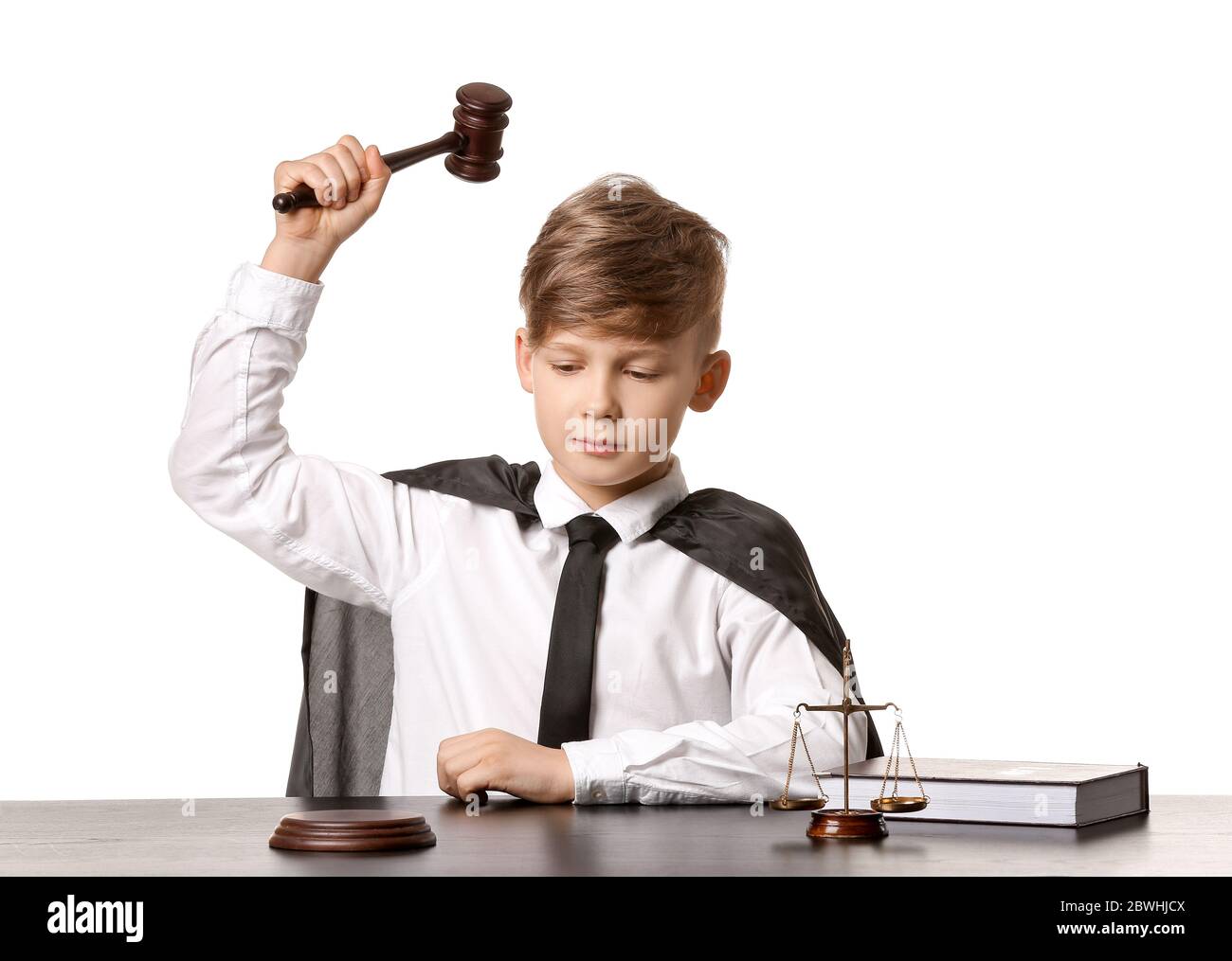Portrait of little judge sitting at table against white background ...
